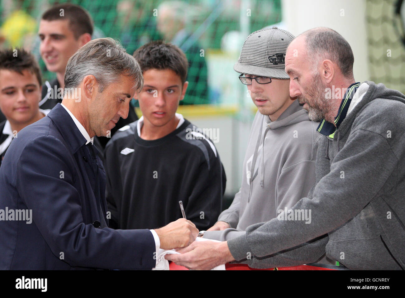 Manchester City manager Roberto Mancini signs autographs as he arrives ...