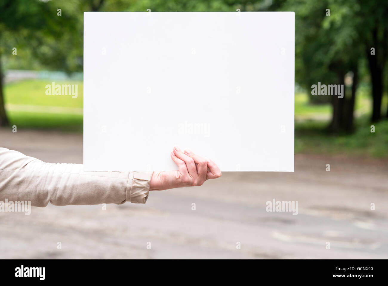 photo of a woman on the outside with an empty white card Stock Photo ...