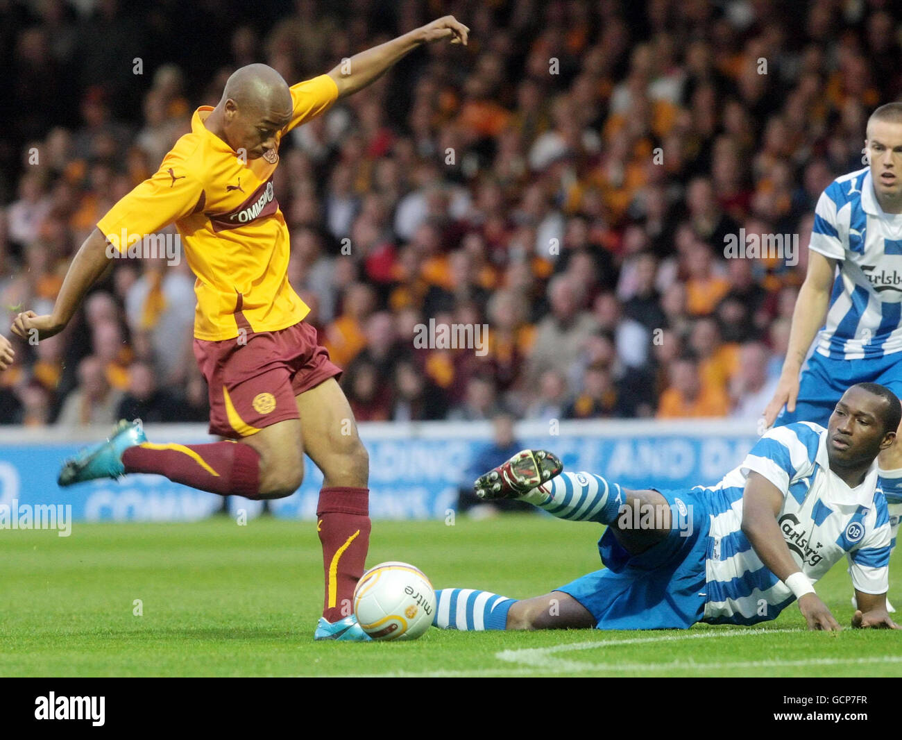 Motherwell's Chris Humphrey (left) strikes at the goal with Odense's ...