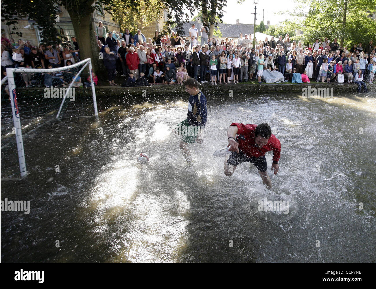 Players during the annual river football match in the River Windrush ...