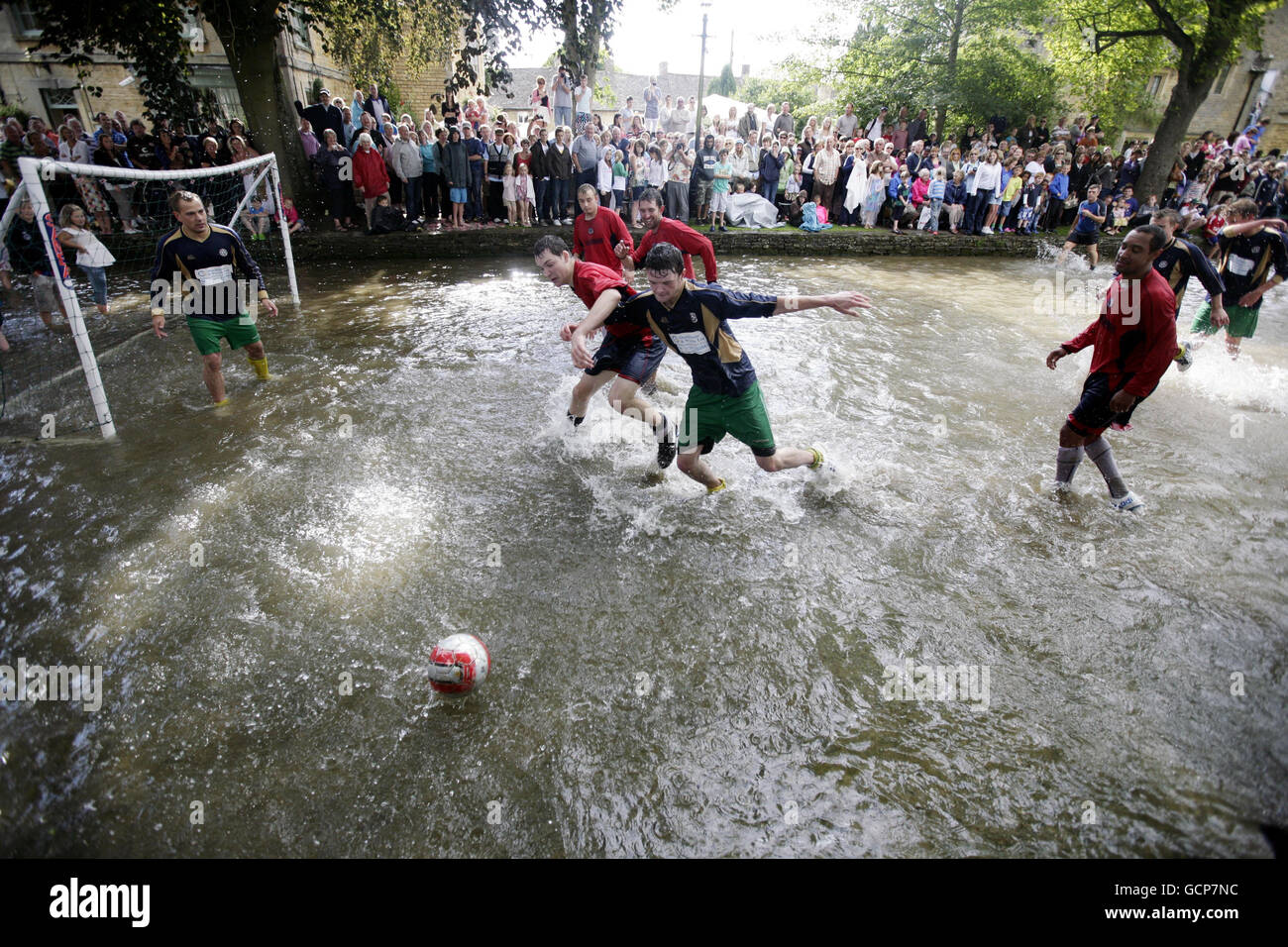 Players during the annual river football match in the River Windrush ...