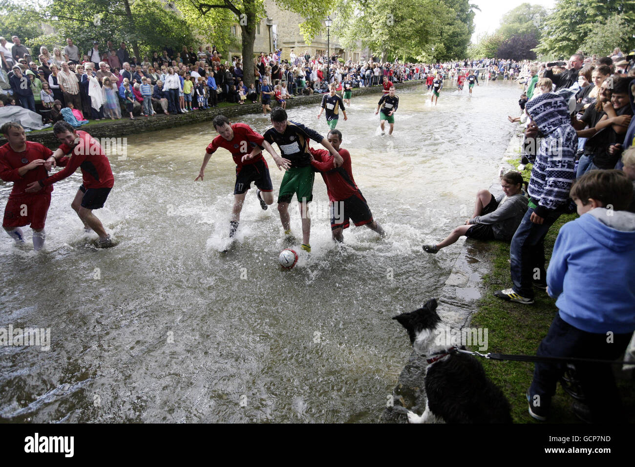 Players during the annual river football match in the River Windrush ...