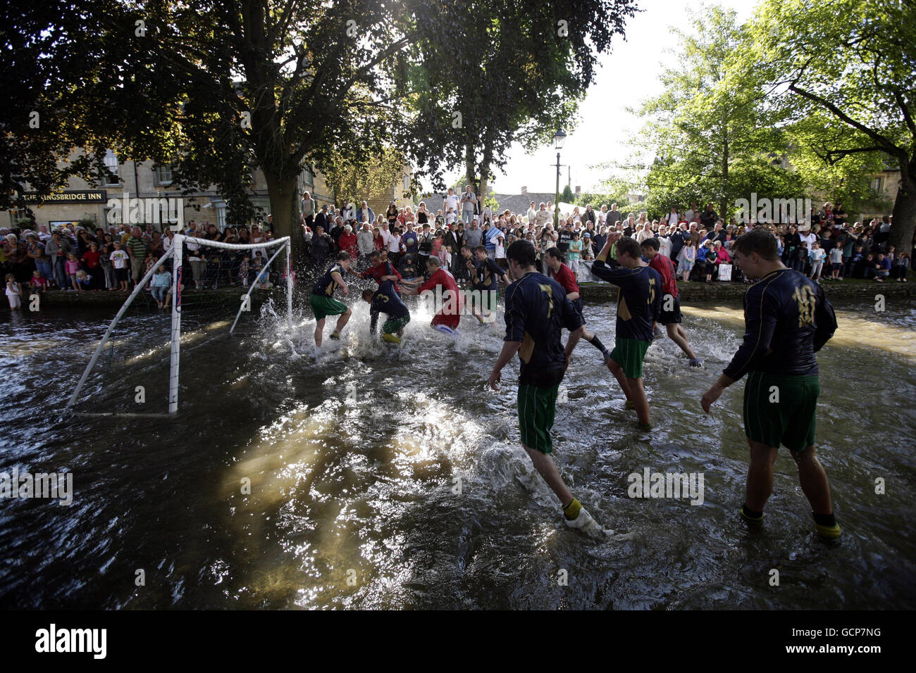 Players during the annual river football match in the River Windrush ...
