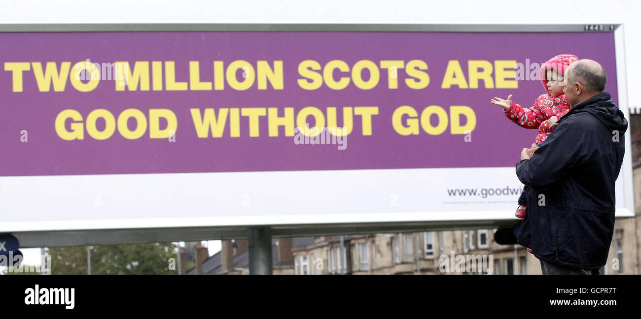 A man and a child look at a Humanist Society of Scotland poster during ...