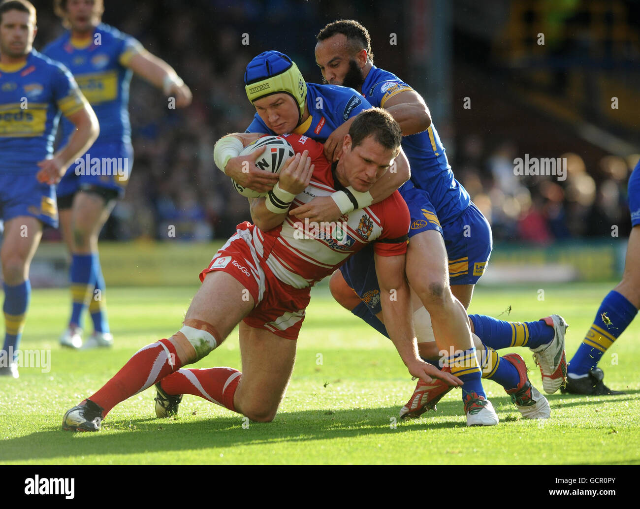 Wigan's Stuart Fielding is tackled by Leeds Rhinos Greg Eastwood and ...