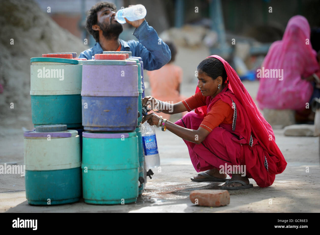 Man woman take water from containers in new delhi hi-res stock ...
