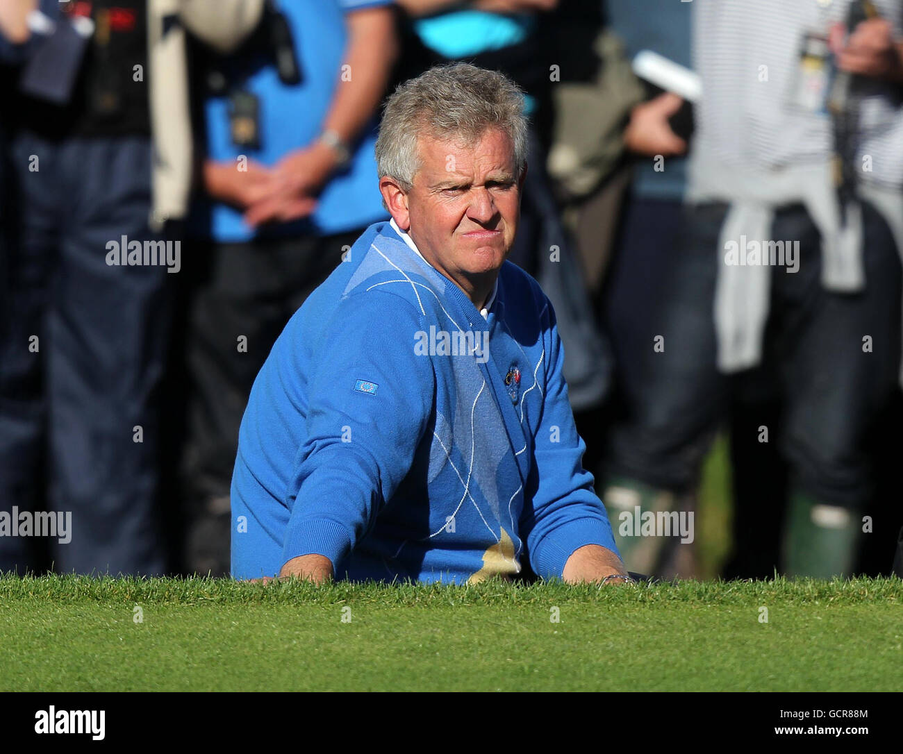 European Captain Colin Montgomerie sits by the side of the 17th green ...