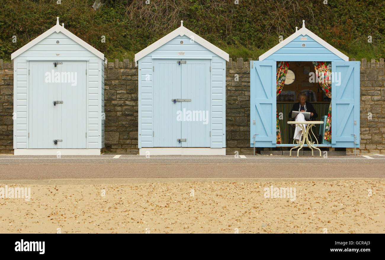 A woman sits in her beach hut on the beach in Bournemouth after weather ...