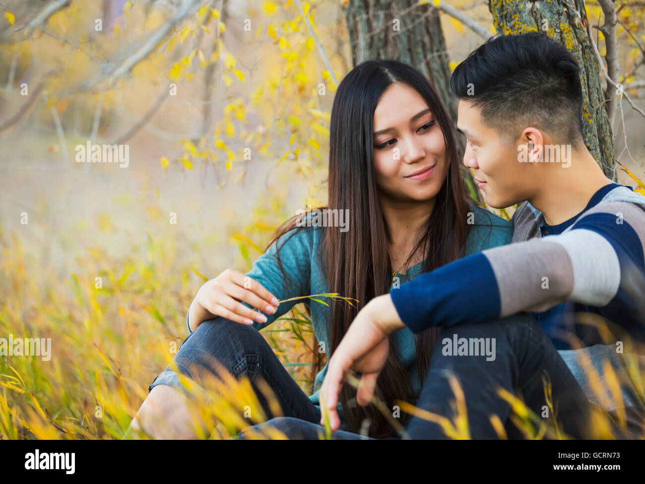 A young Asian couple enjoying a romantic time together outdoors in a ...