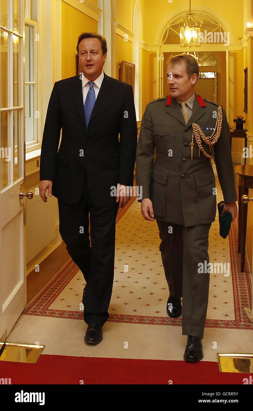 Prime Minister David Cameron (L) walks with his new military assistant ...