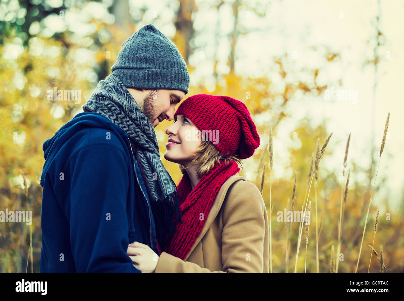 A young couple looking into each other's eyes and kissing in a city ...