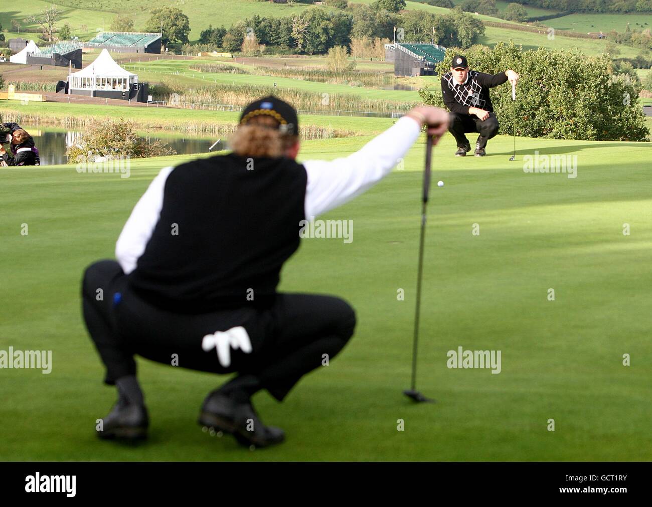 Europe's Miguel Angel Jimenez (left) and Peter Hanson line up a putt ...