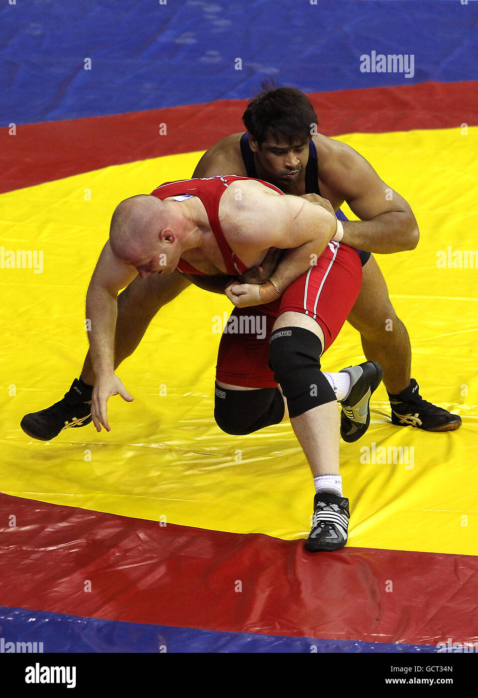 England's Mark Cocker (red) in action against India's Dharmender Dalal ...