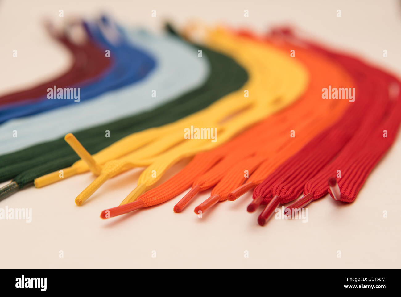 Rainbow coloured laces on a white background Stock Photo - Alamy