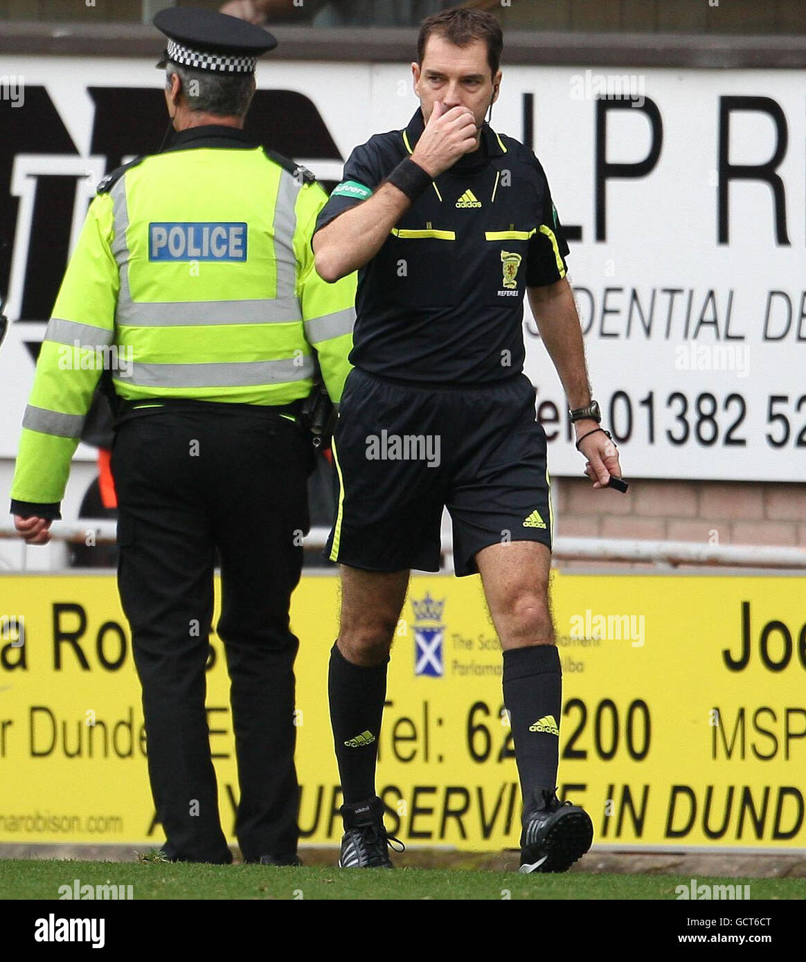 Referee Dougie McDonald after handing something thrown onto the pitch ...