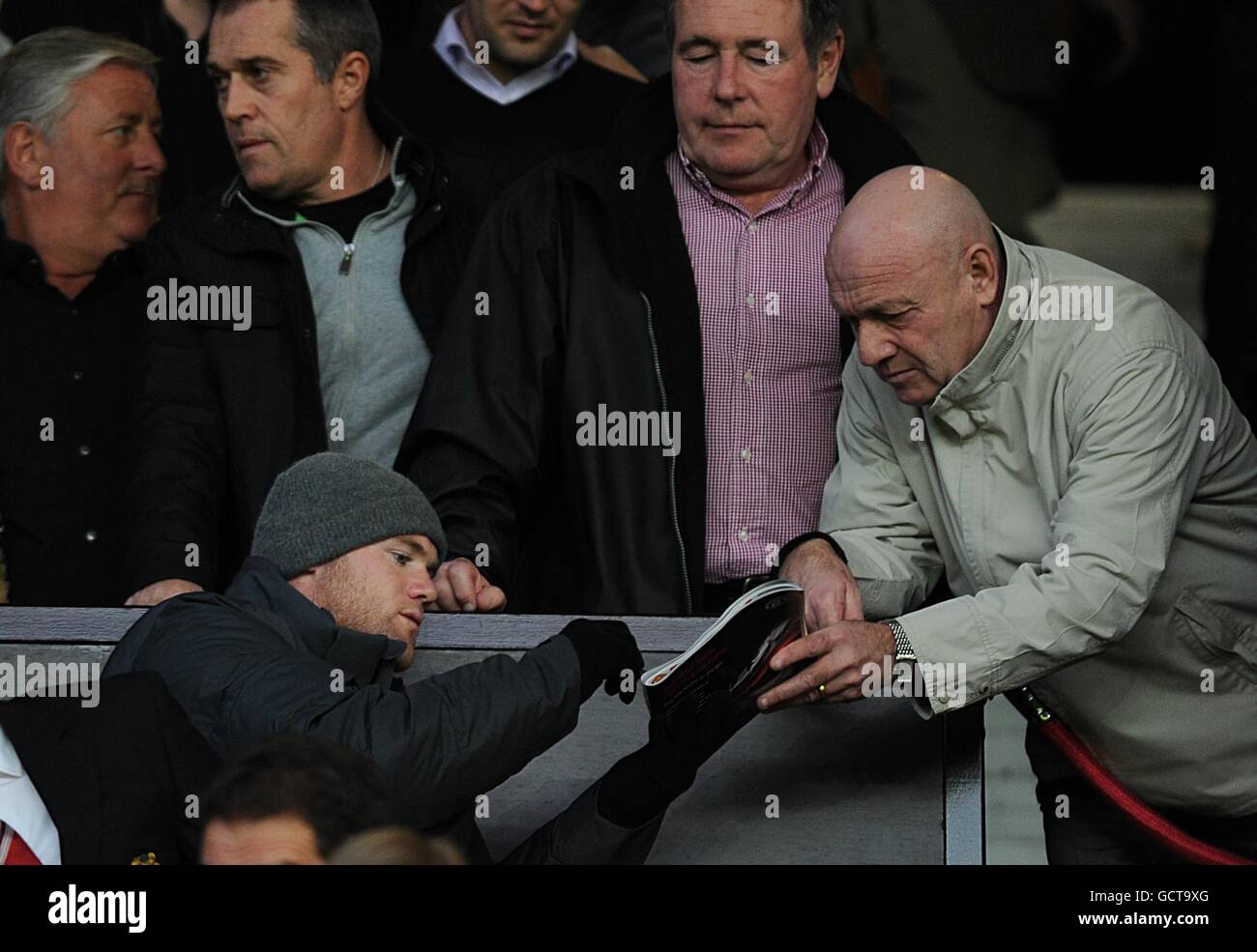 Manchester United's Wayne Rooney(left) signs an autograph in the stands ...