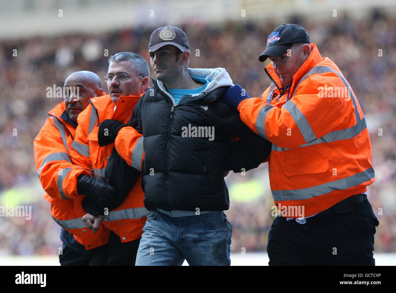 Pitch invader is escorted off the pitch by the stewards hi-res stock ...