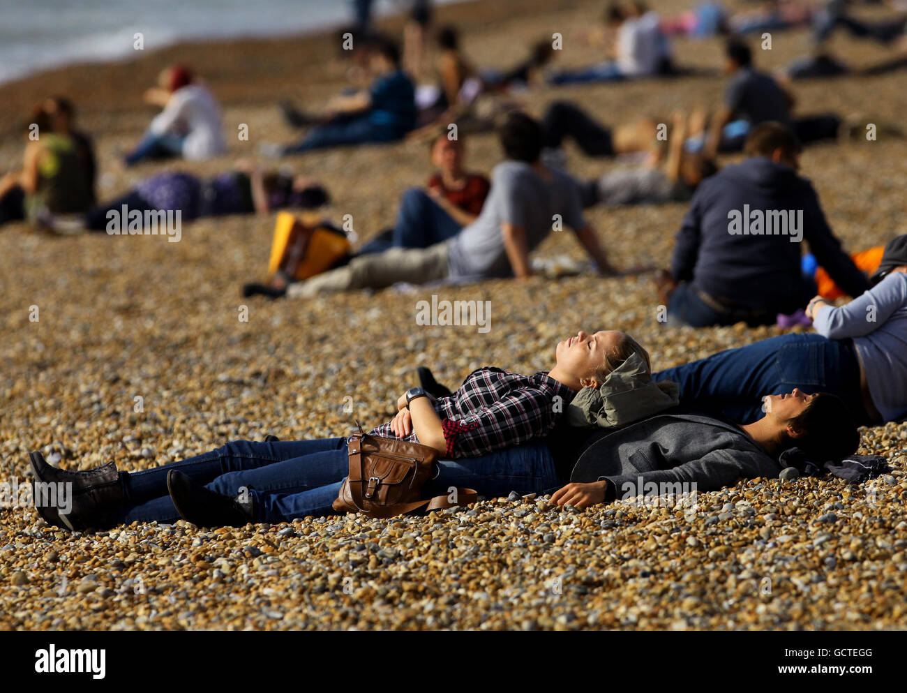 A couple enjoy the warm October weather on the beach in Brighton, East ...