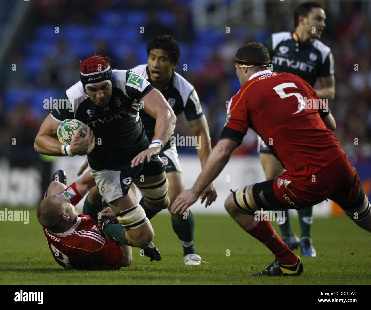 London Irish's Nick Kennedy (centre) is held by Munster's Tony Buckley ...