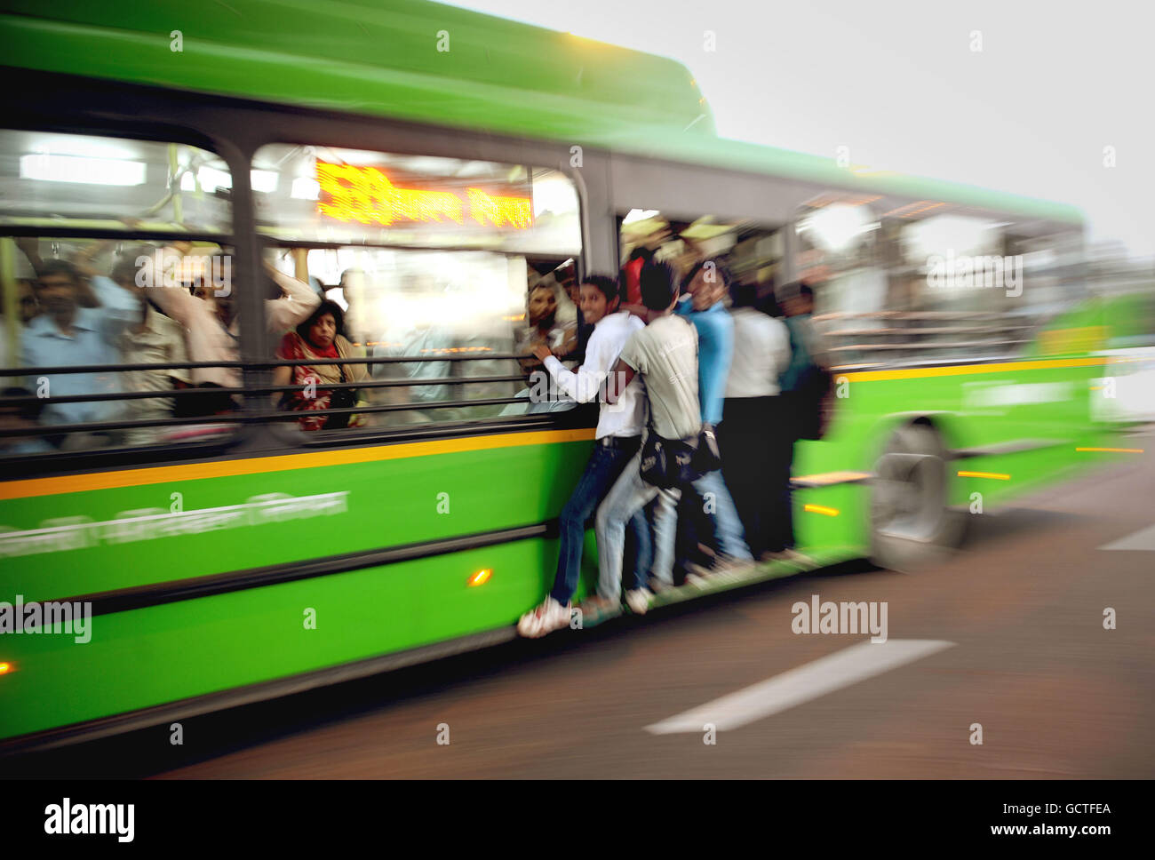 People travel on the outside of a bus in New Delhi, India Stock Photo ...