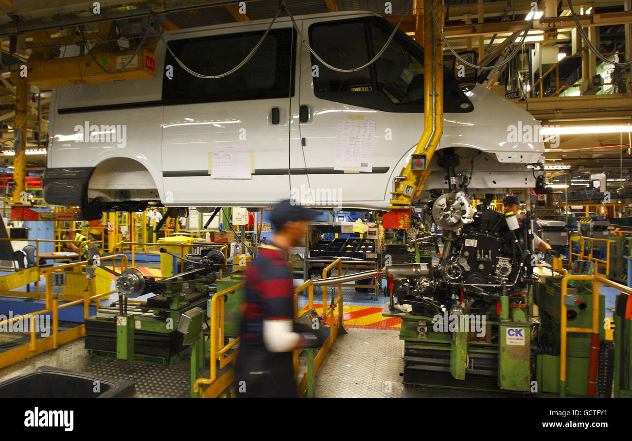 Ford workers fit an engine into a Transit van at their factory in ...