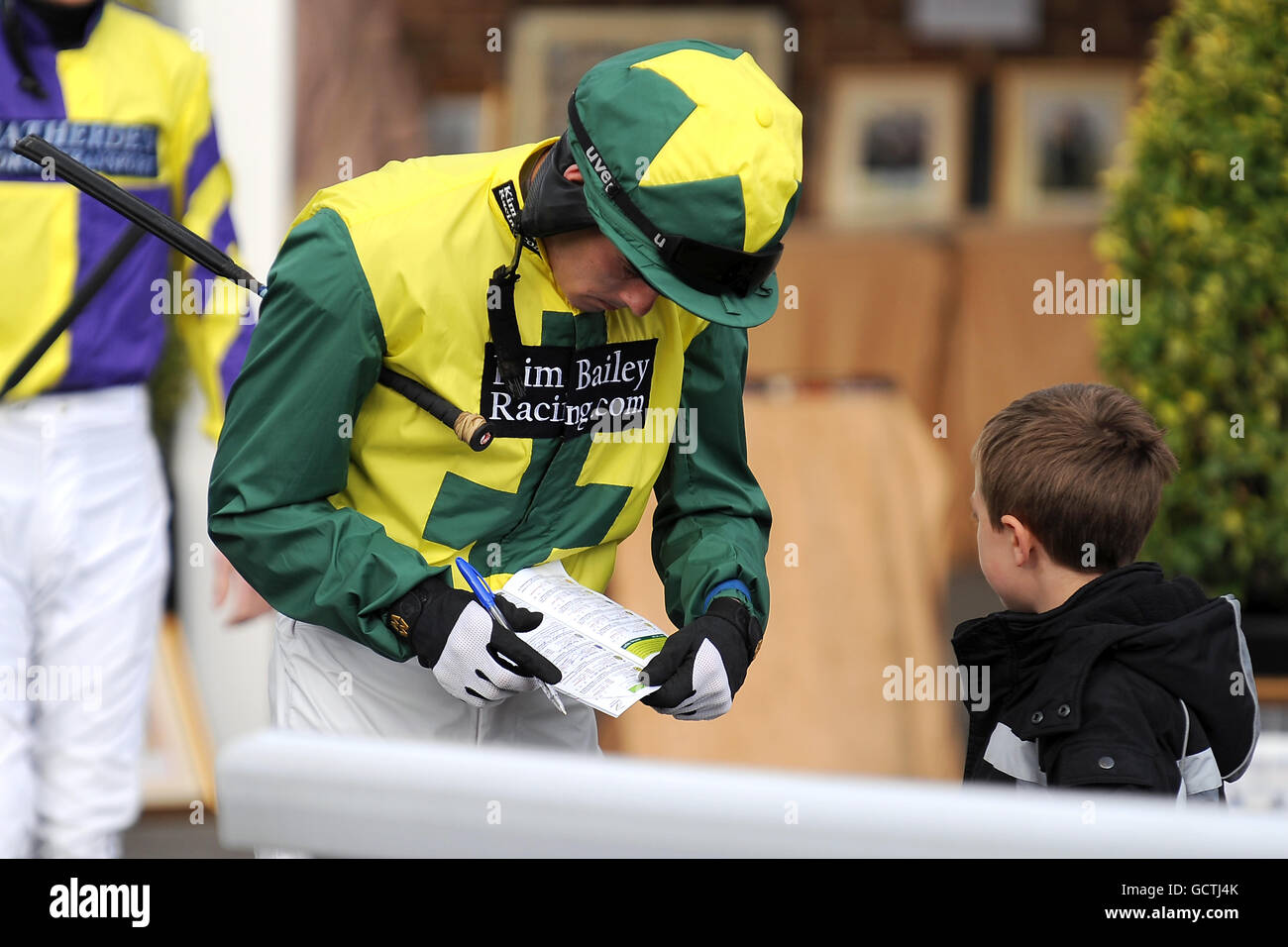 Jockey Sean Quinlan signs an autograph for a young fan prior to his ...