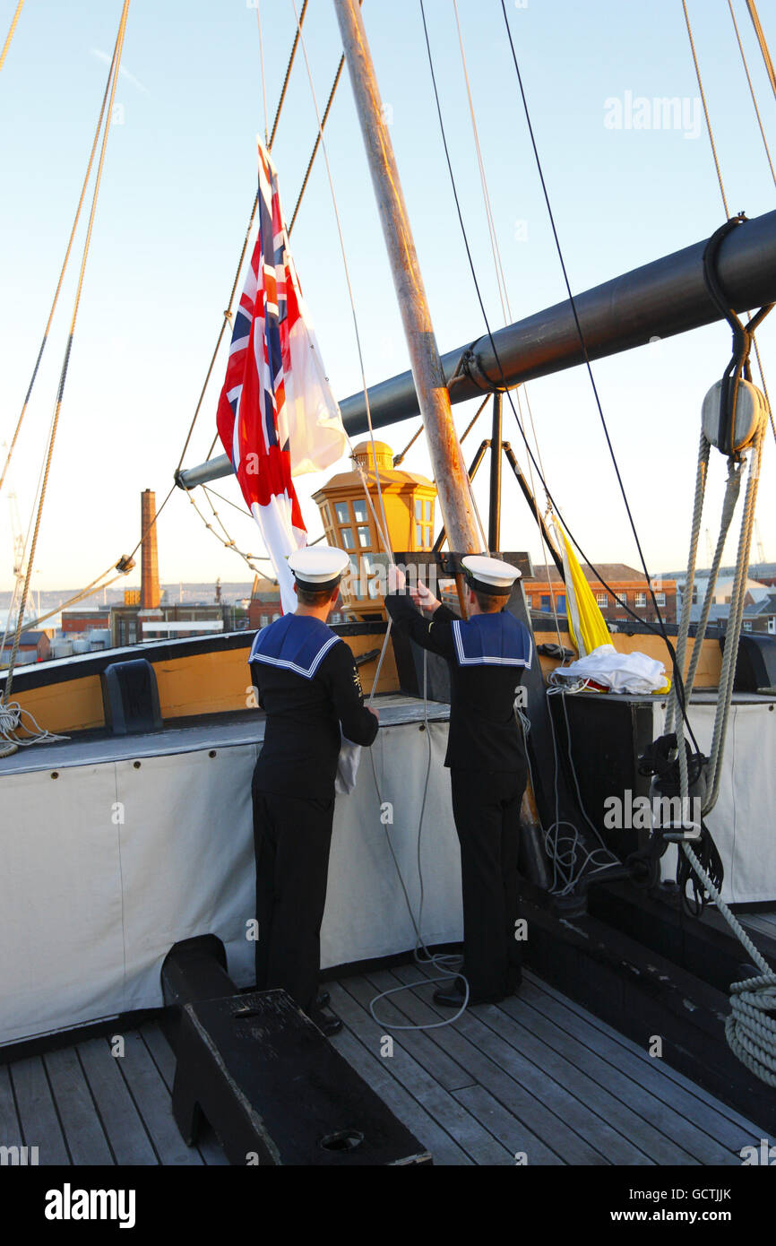 Two Ratings raise the white ensign at the stern of HMS Victory in ...