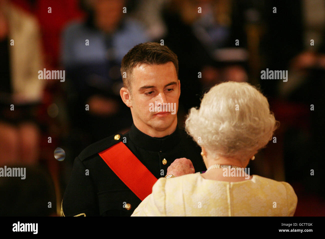 Queen Elizabeth II presents Sergeant Adam Swift, of the Coldstream ...