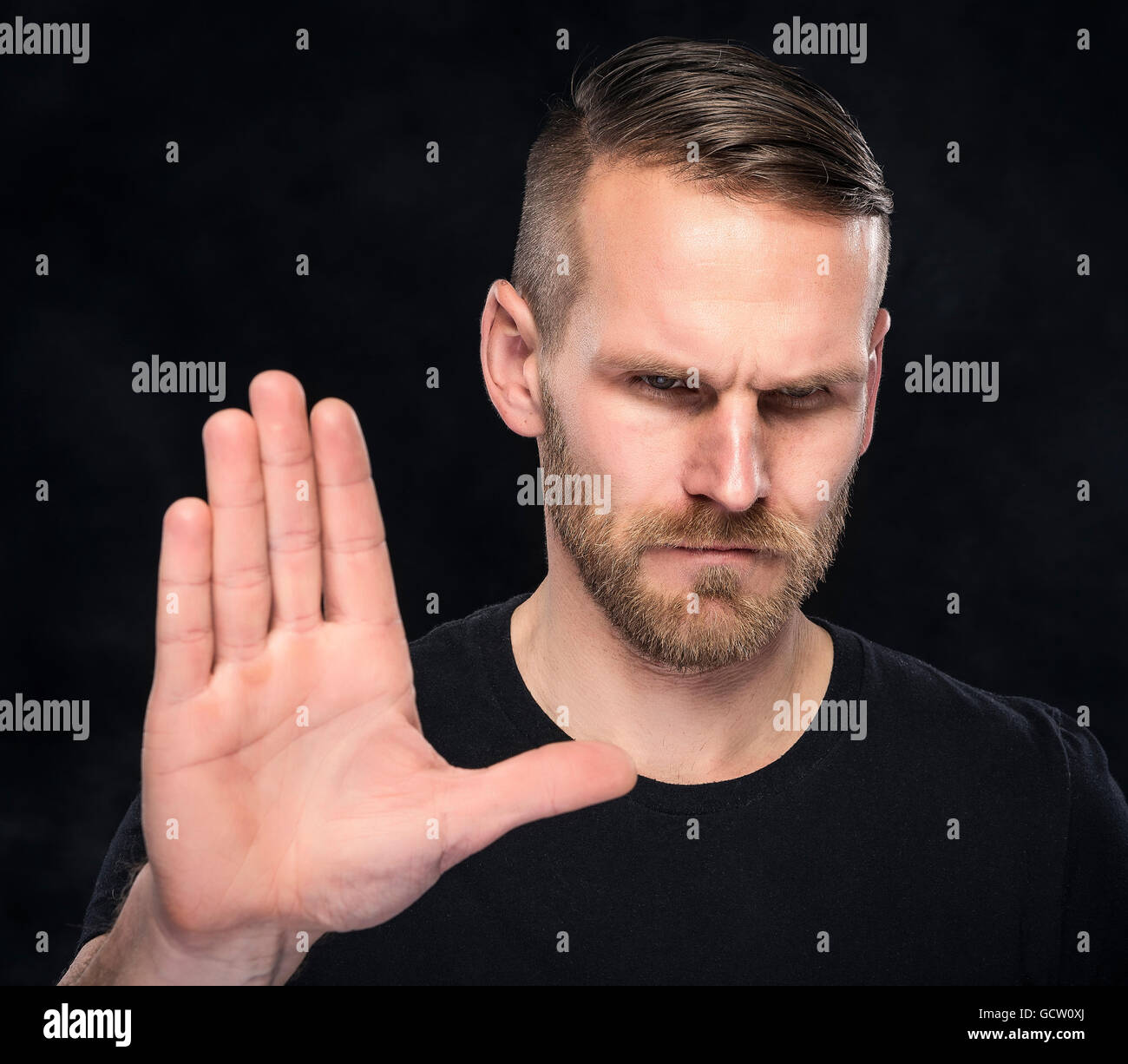Man gesturing stop sign on a dark background Stock Photo - Alamy