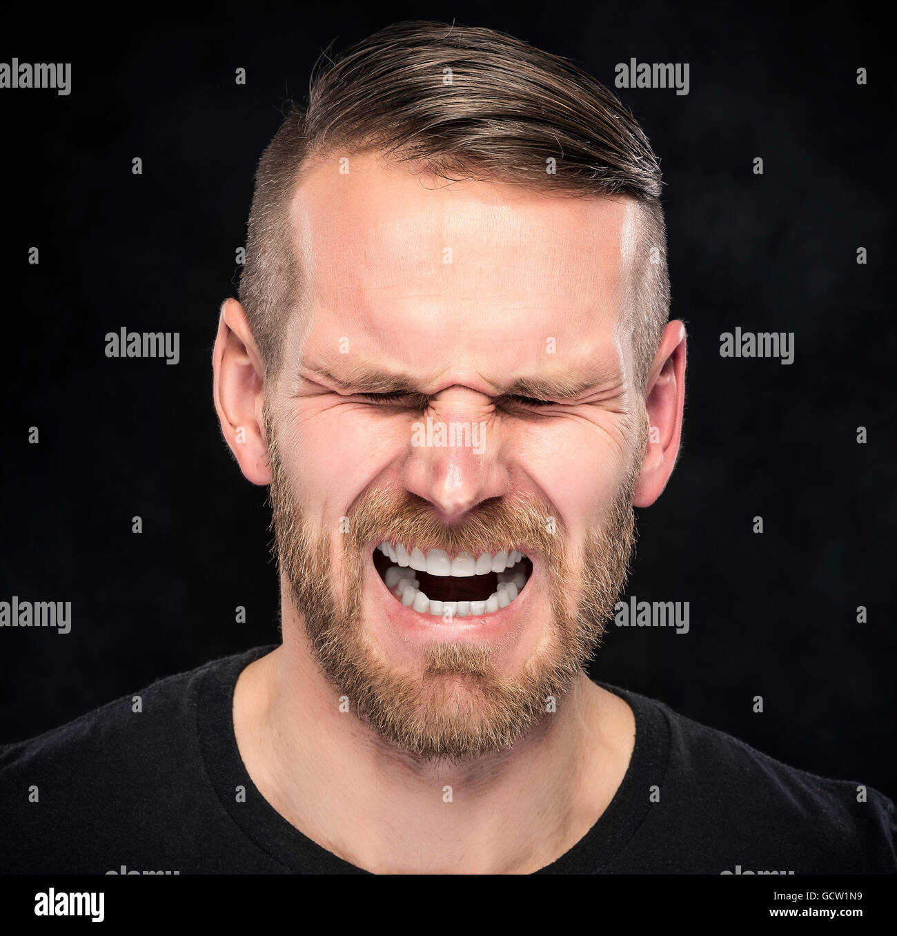 Young man screaming on a dark background Stock Photo - Alamy
