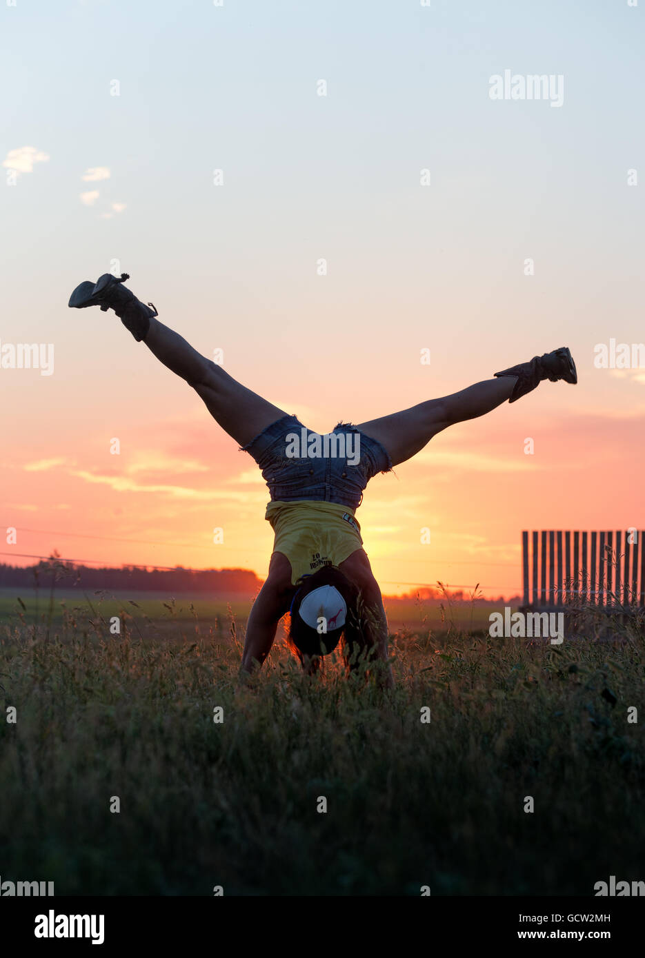Girl doing handstand and splits in a field at sunset Stock Photo - Alamy