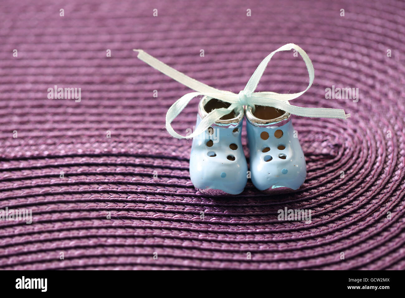 Small shoes on the violet background Stock Photo - Alamy
