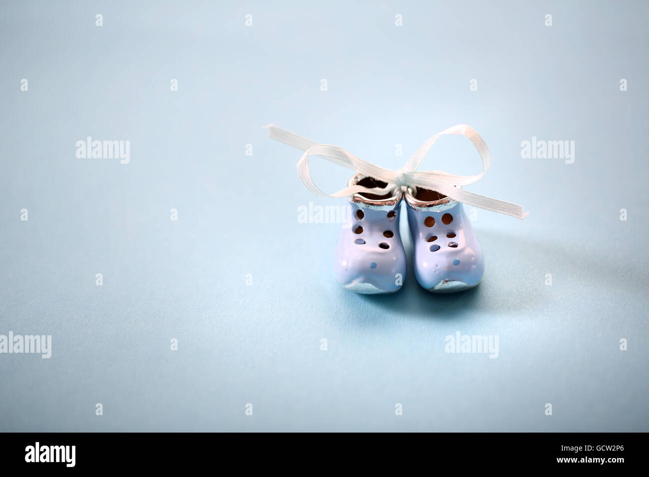 Small shoes on the blue background Stock Photo - Alamy