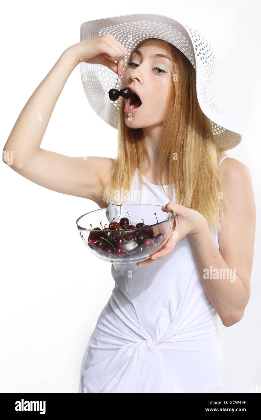 Young pretty woman with cherry on the white background Stock Photo - Alamy
