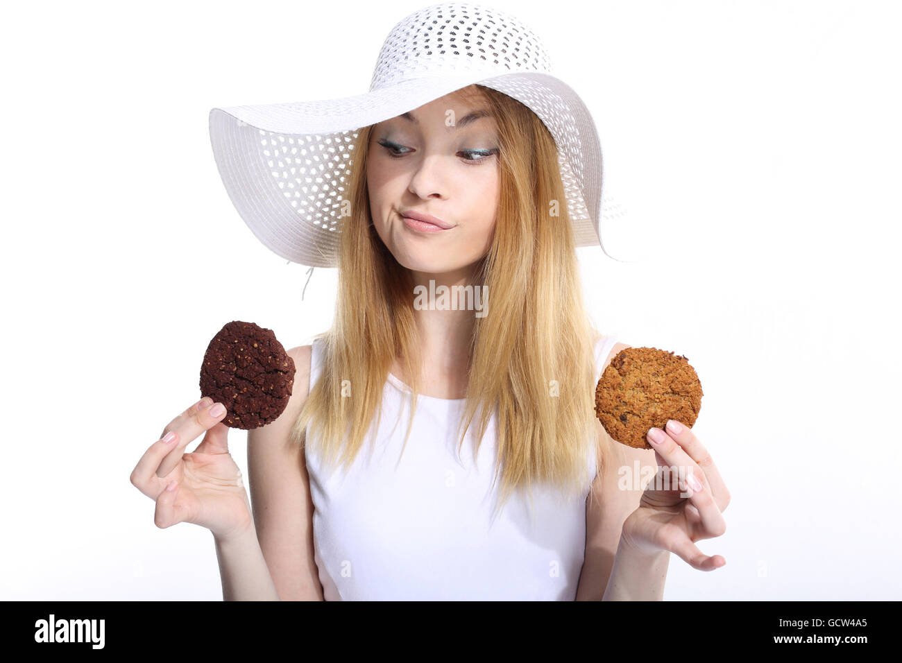 Cute young woman eats cookies on the white background Stock Photo - Alamy