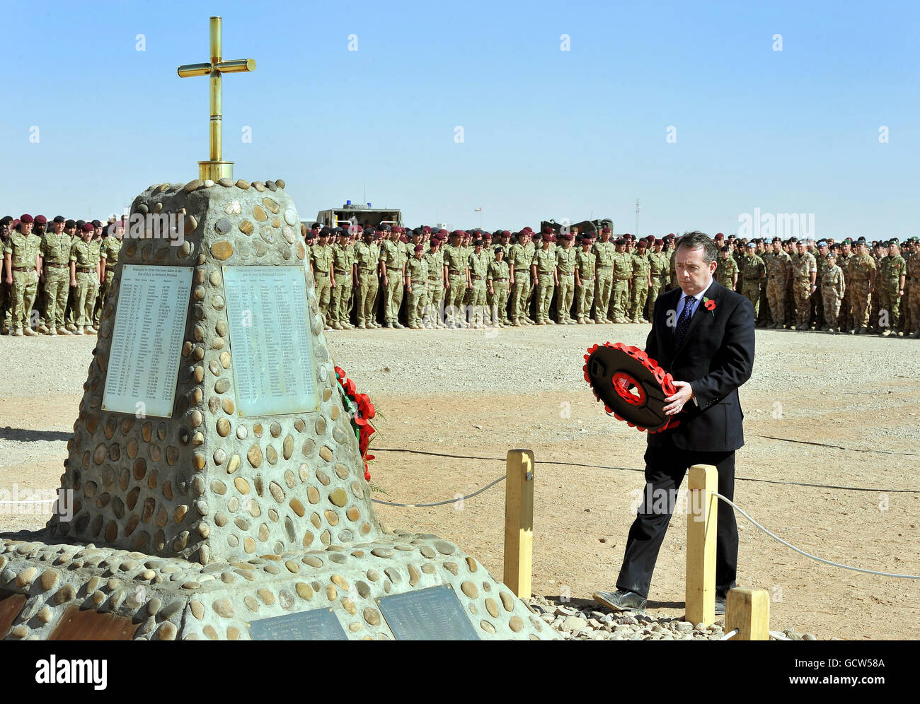 The Secretary of State for Defence Dr Liam Fox, walks forward to place ...