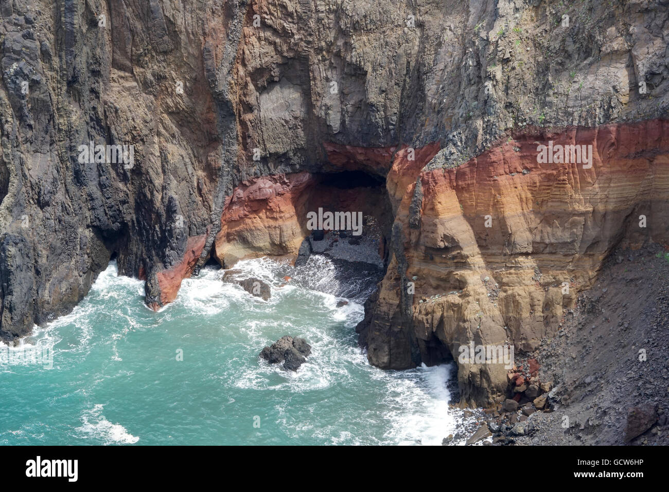 volcanic rock in the ocean with multi-colored layers Stock Photo - Alamy