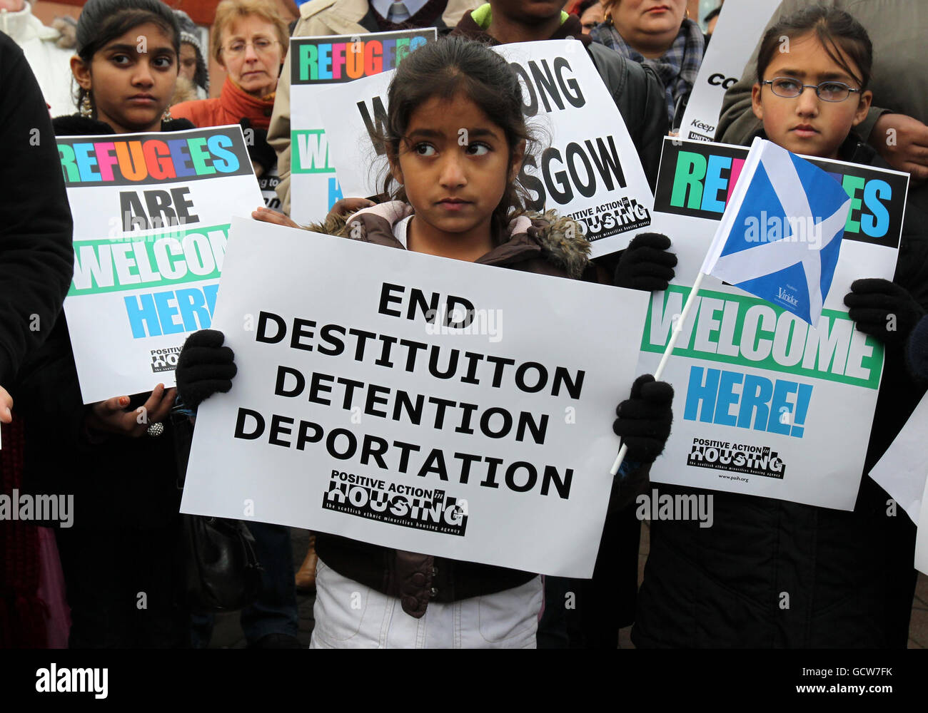 Protesters hold up banners during the Anti-UK Borders Agency ...