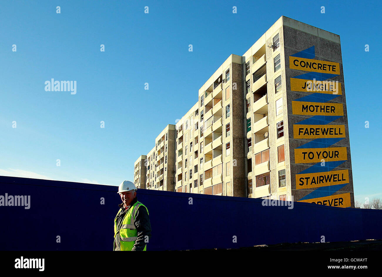 A construction worker passes a tower block, due to be demolished as ...