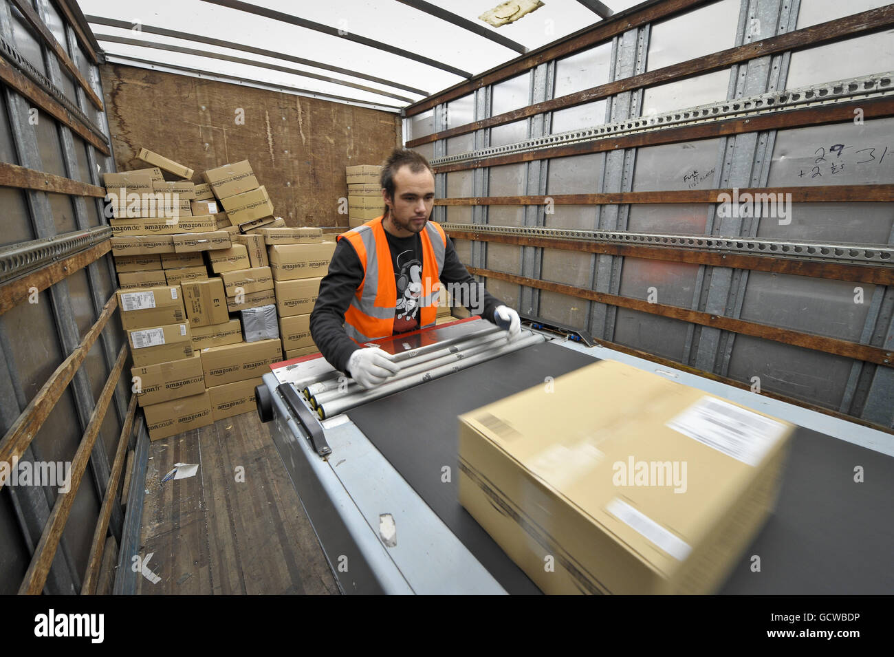 An Amazon worker packs boxes into an articulated lorry after being ...