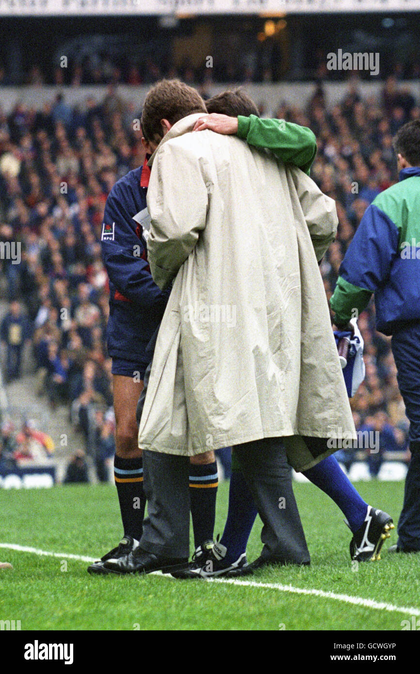 Referee Colin Hawke (from New Zealand) is helped off the pitch by ...