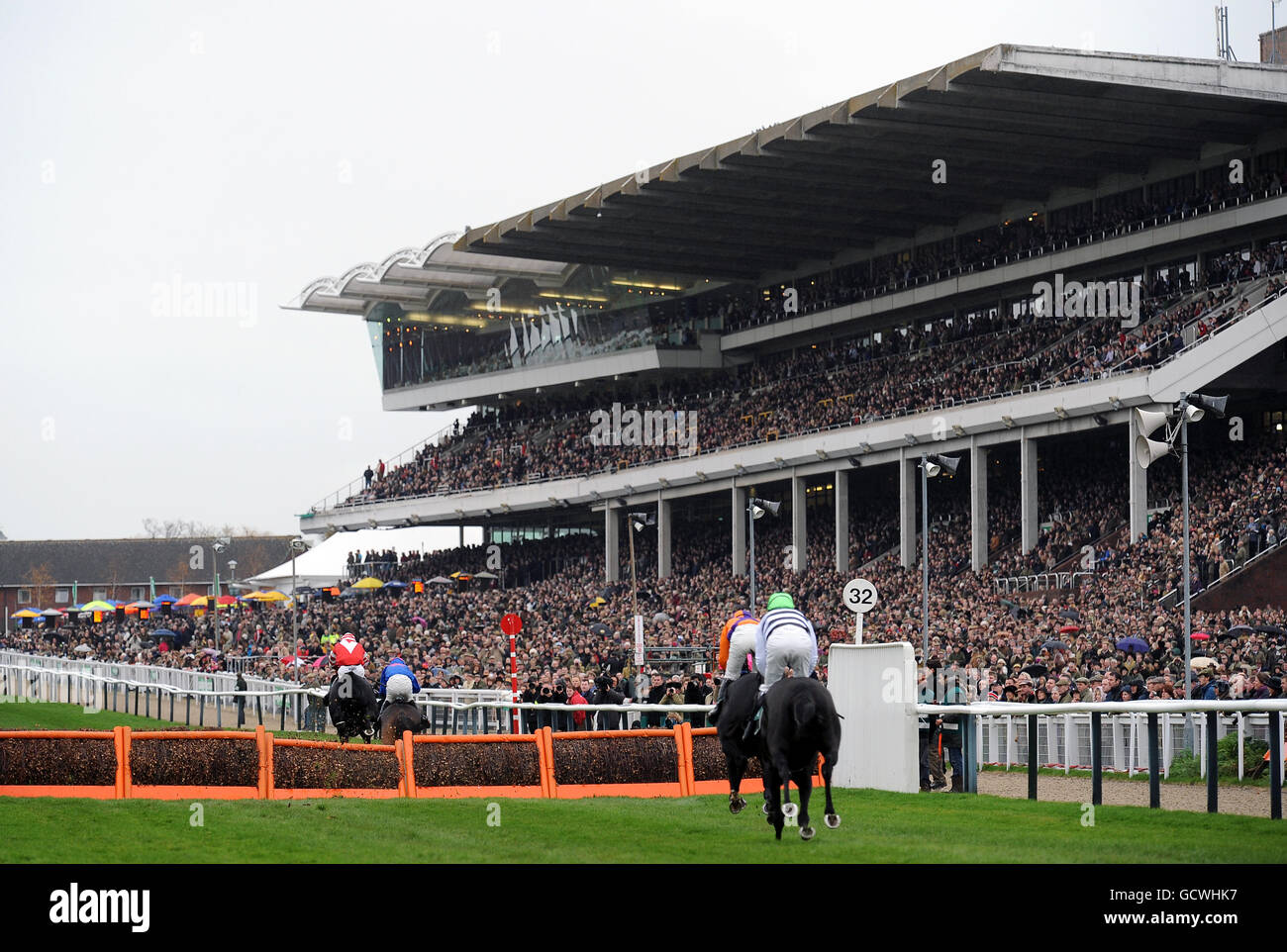 Riders ride past the grandstand at Cheltenham Racecourse Stock Photo ...