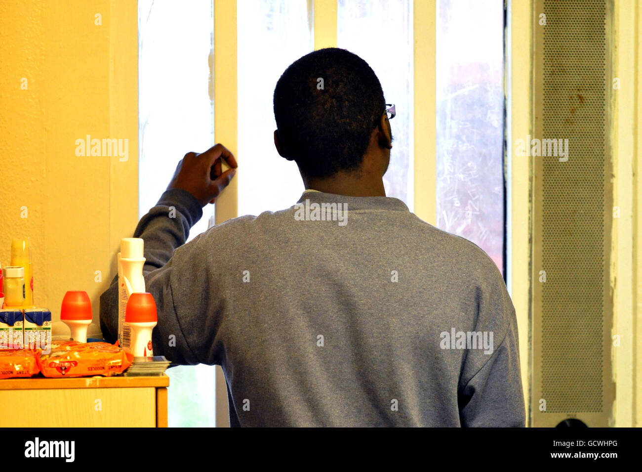 A young inmate looks out of the window of a cell during a visit by ...