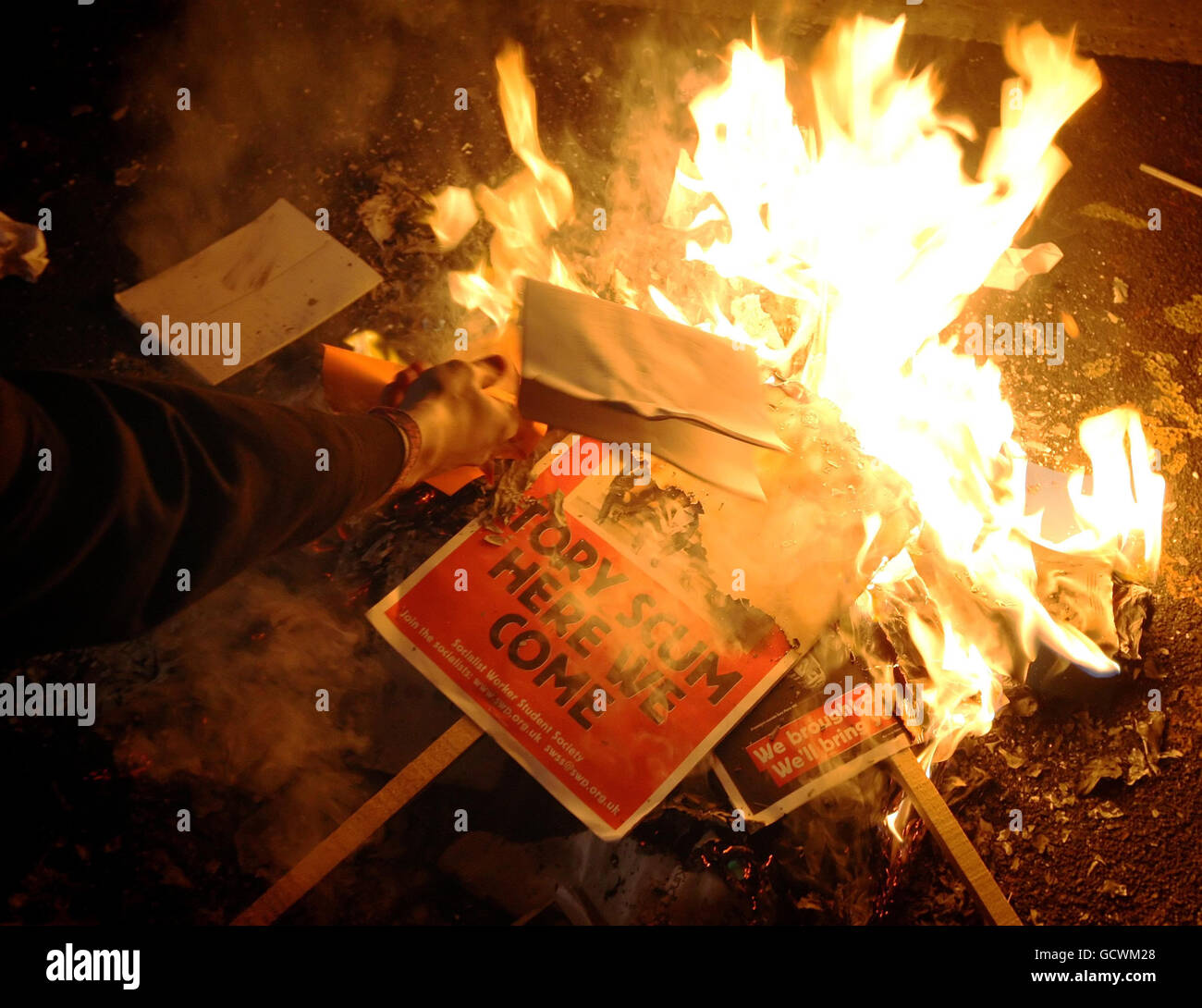 A person throws a placard onto a bonfire of placards during protests in ...