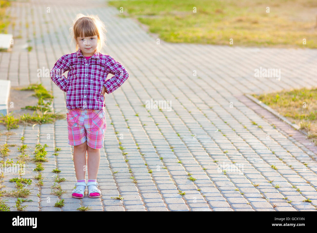 Little girl on summer day standing with hands on hips Stock Photo - Alamy