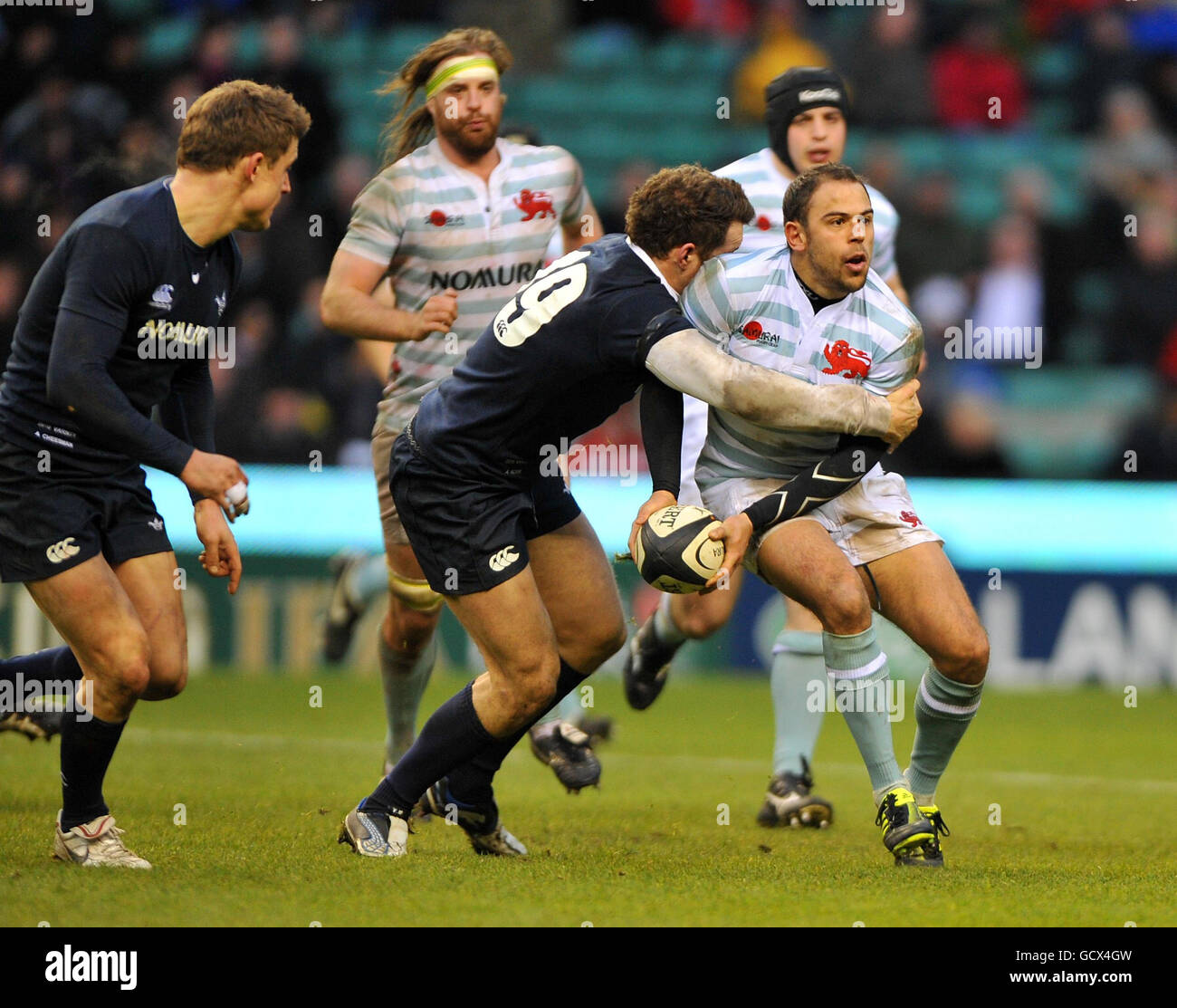 Oxford's Alex Rowe (centre) tackles Cambridge's James Richards during ...