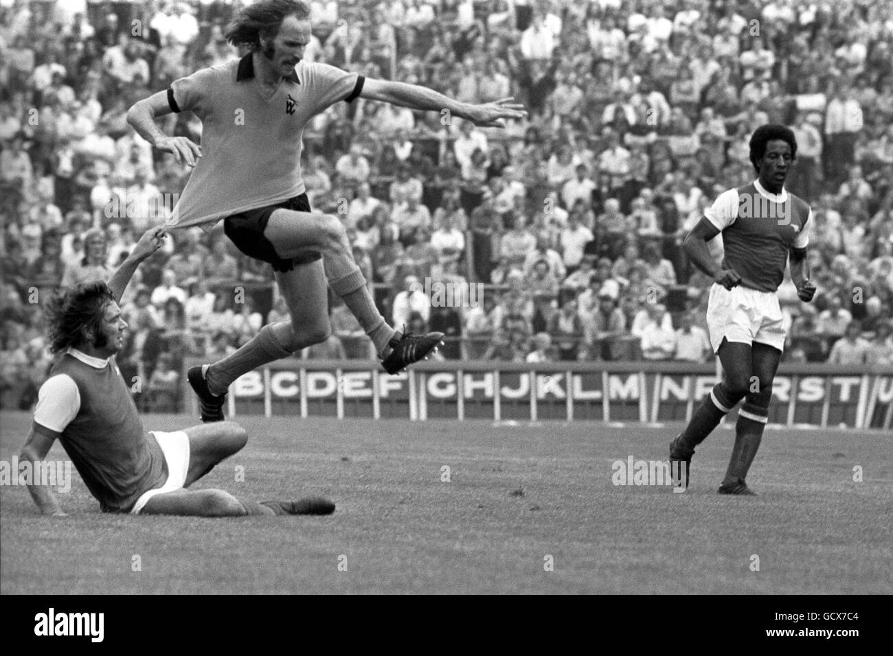 Arsenal's Peter Simpson pulls on the shirt of Derek Dougan ...