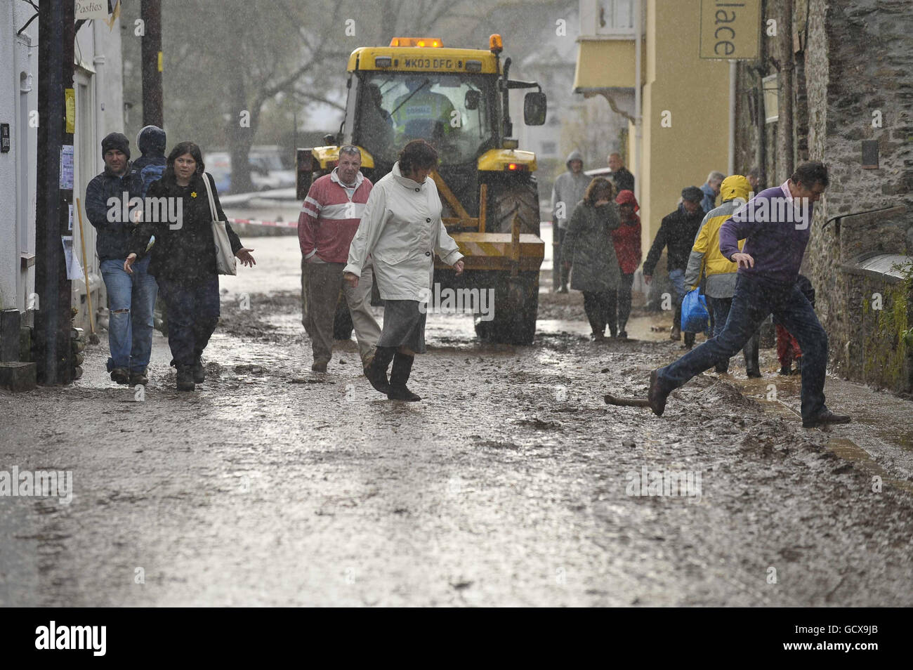 People try to avoid the heavy mud and rain in the streets in ...