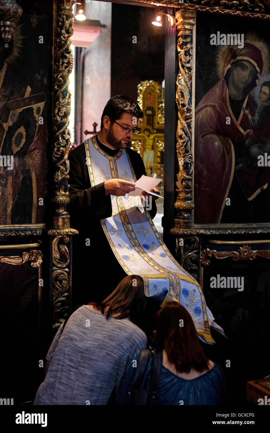 A Romanian Orthodox priest gives blessings to believers inside St ...
