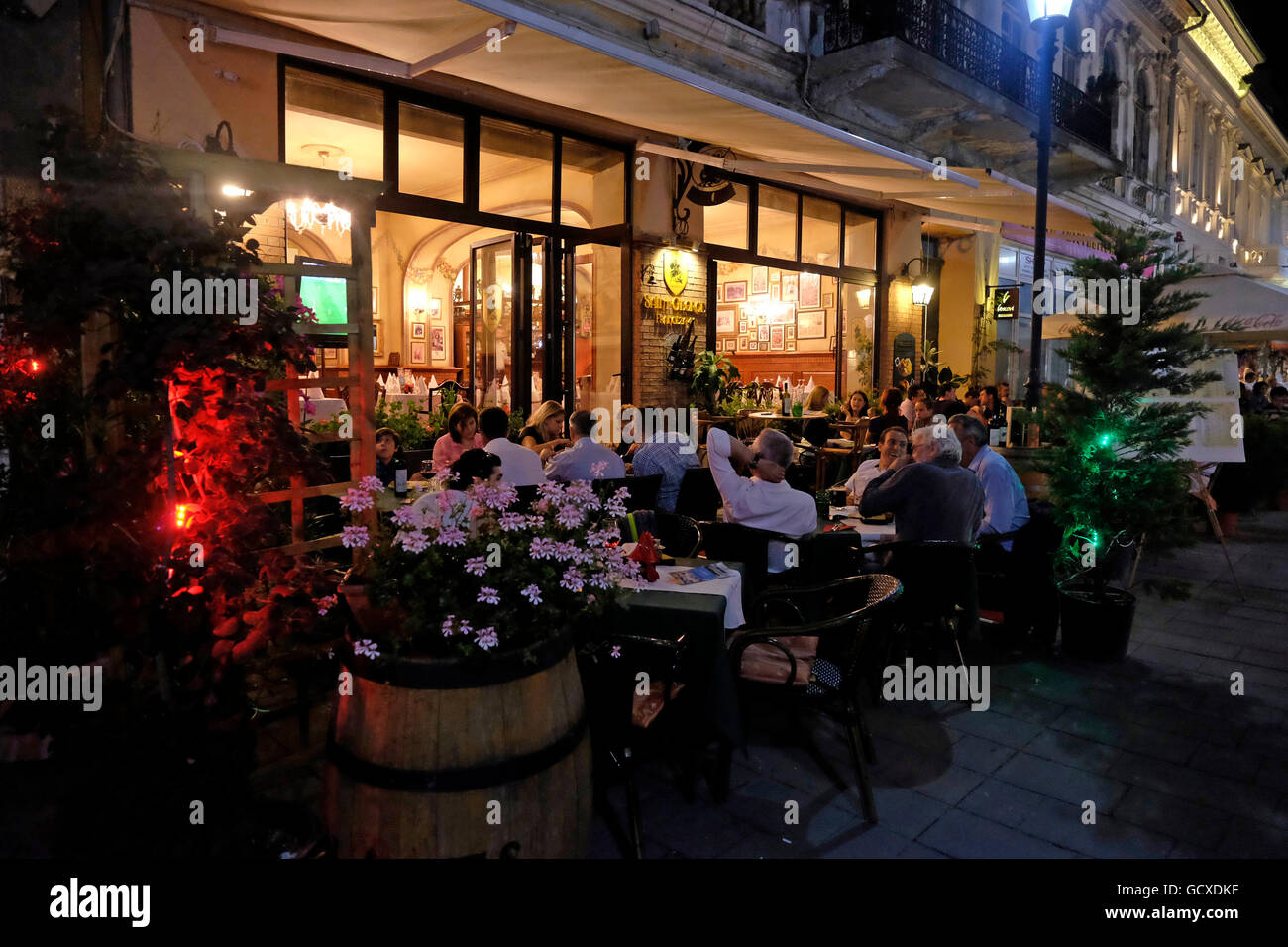 People sit in a restaurant in the historic part old city Bucharest ...